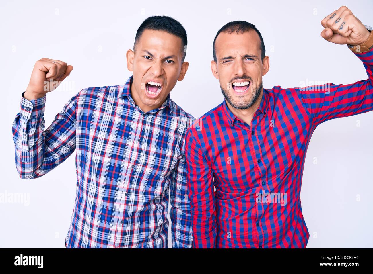 Young gay couple of two men wearing casual clothes angry and mad ...