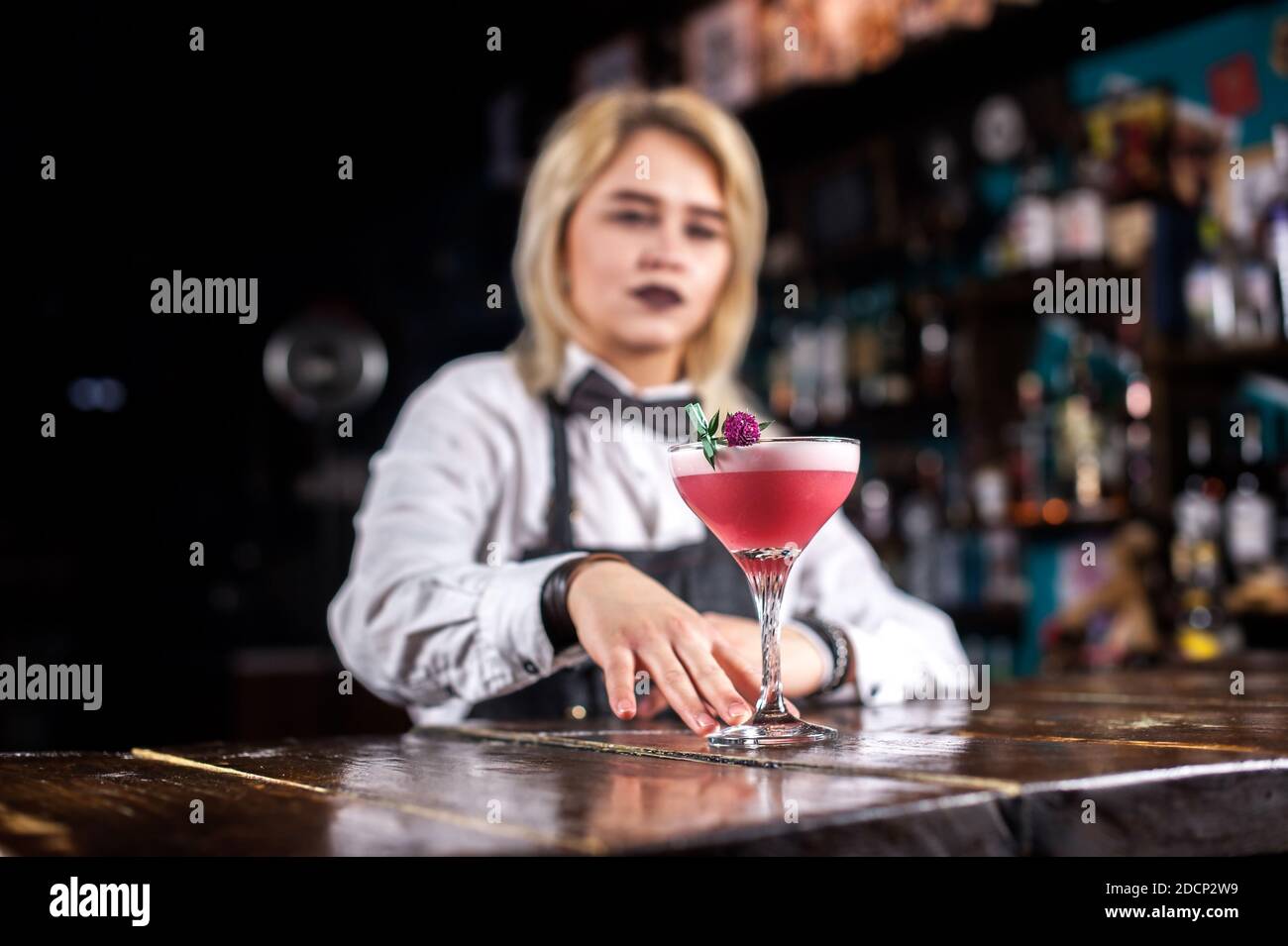 Expert woman mixologist demonstrates the process of making a cocktail ...