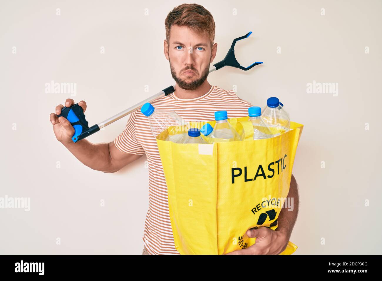 Young caucasian man holding recycling bag with plastic bottles and ...