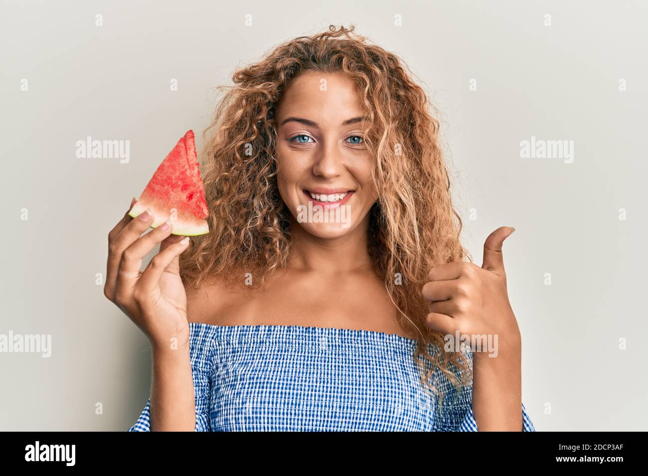 Beautiful caucasian teenager girl eating sweet watermelon slice smiling ...