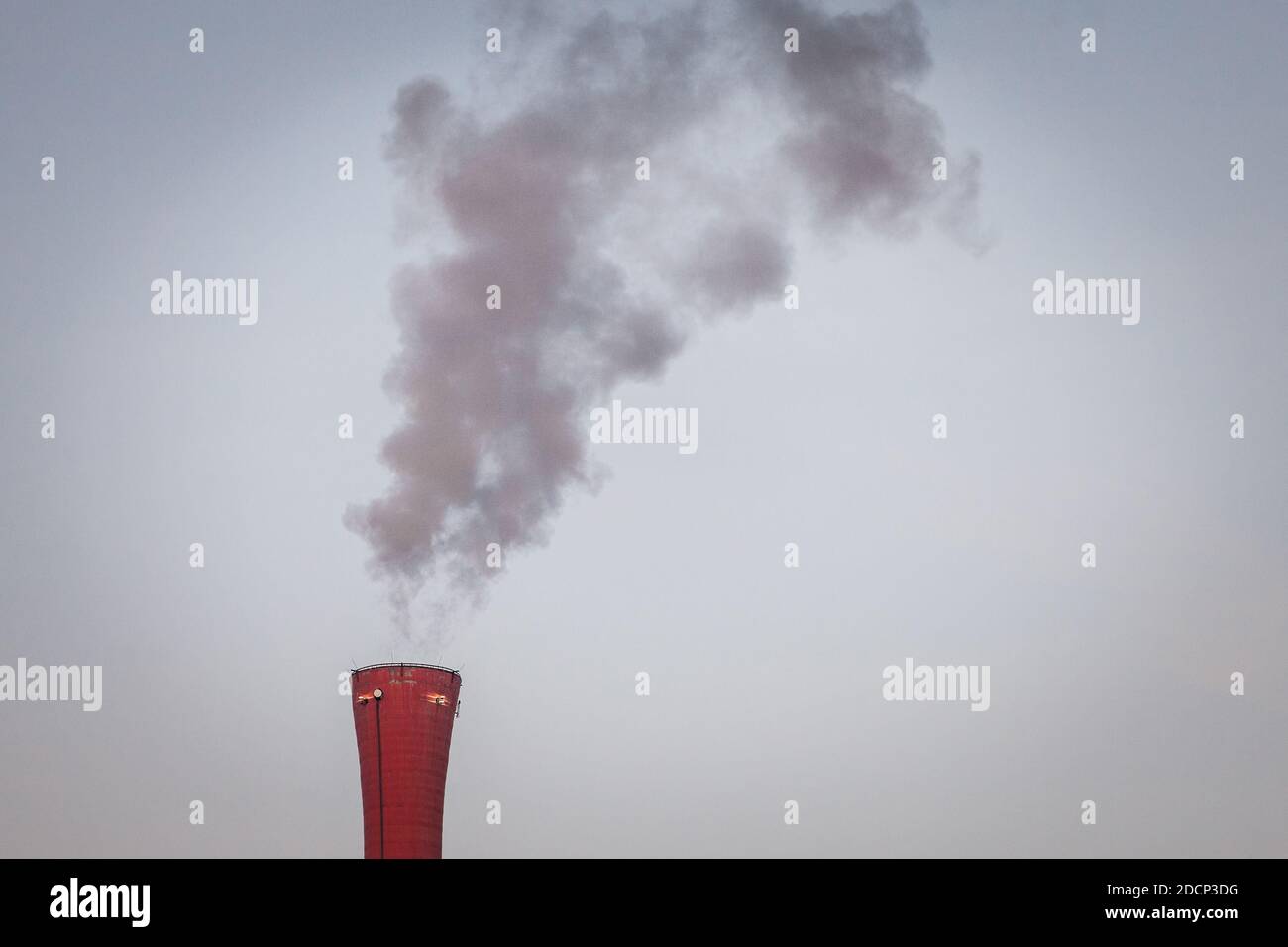 Industrial red chimney of a factory working and releasing toxic fume ...