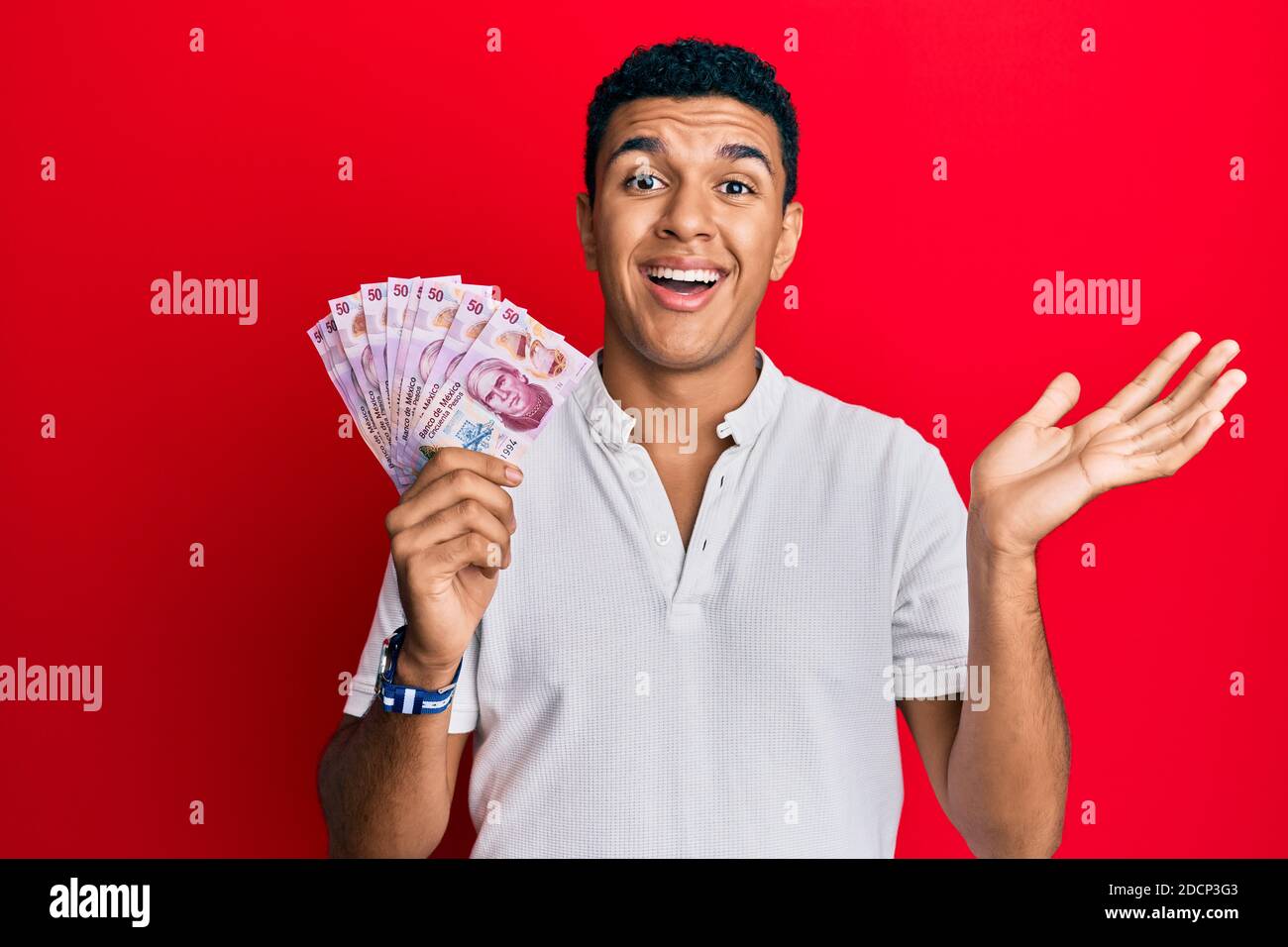 Young arab man holding mexican pesos celebrating achievement with happy ...