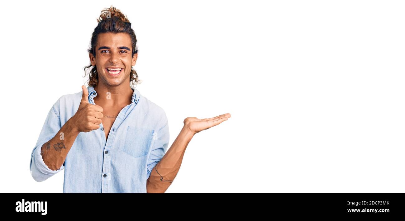 Young hispanic man wearing summer style showing palm hand and doing ok ...