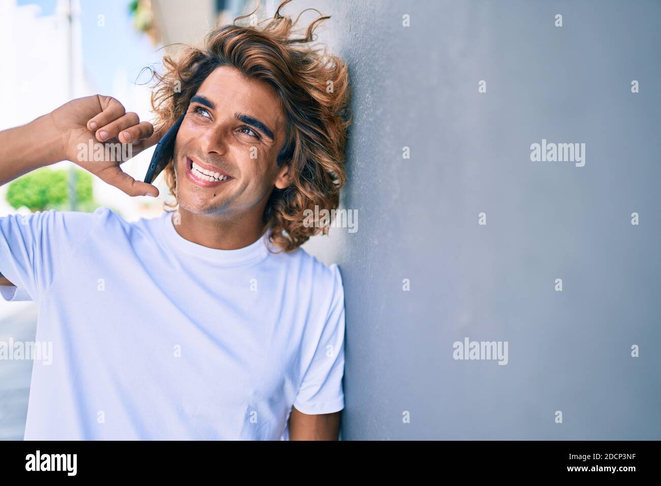 Young hispanic man having conversation talking on the smartphone ...