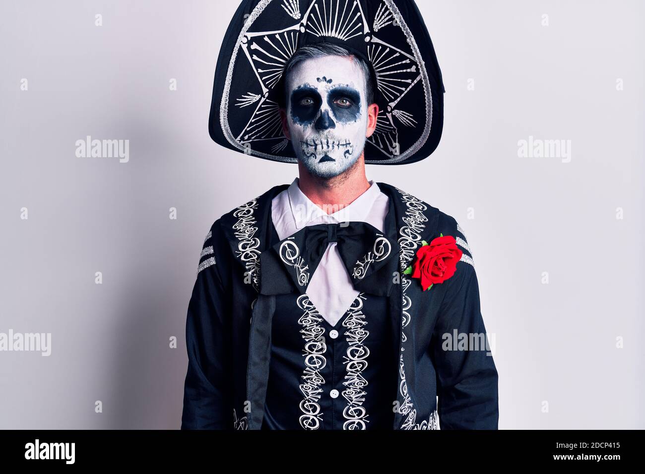Young man wearing mexican day of the dead costume over white relaxed ...