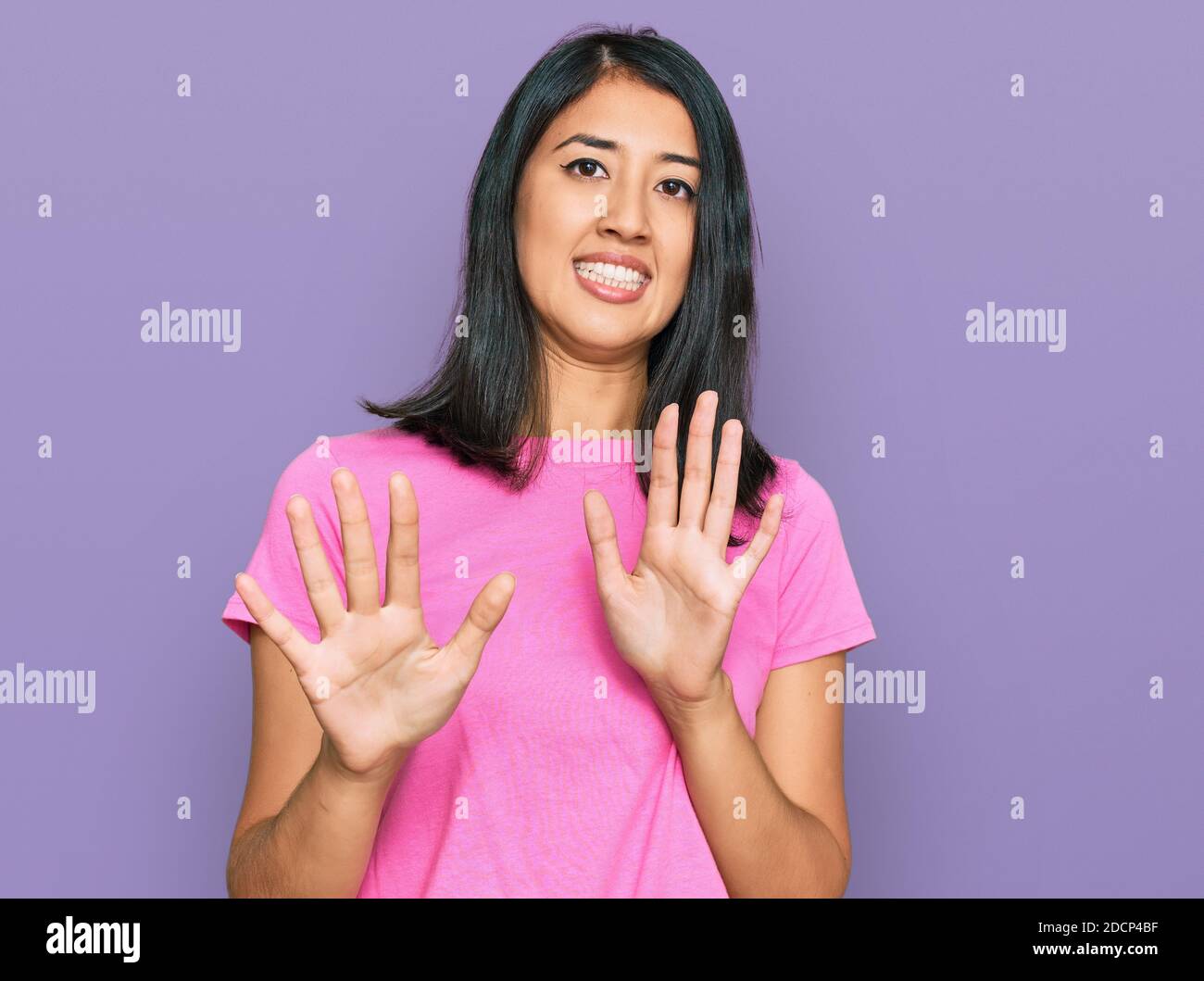 Beautiful asian young woman wearing casual pink t shirt afraid and ...