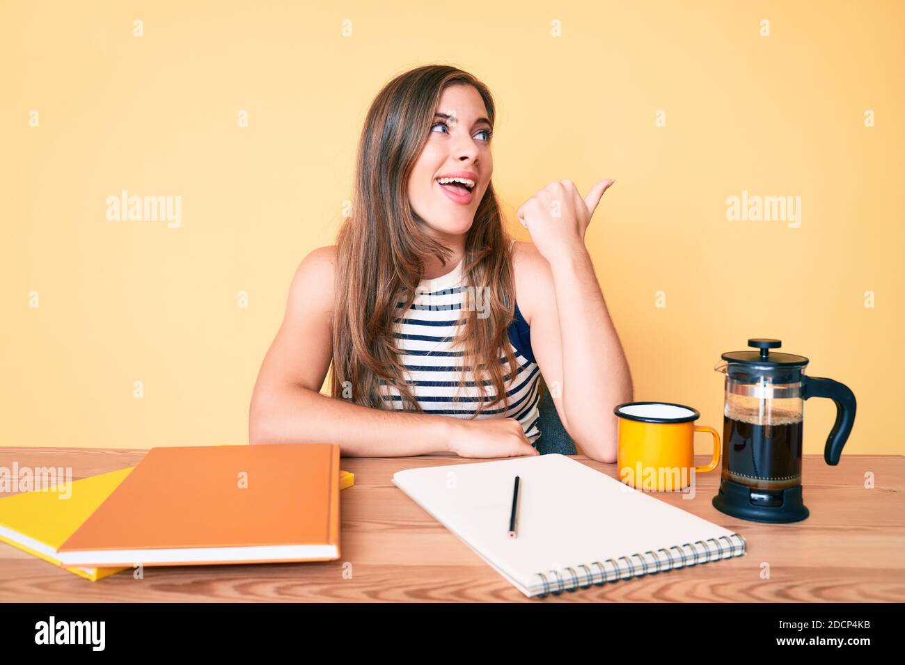 Beautiful young caucasian woman sitting on the table stuying for ...