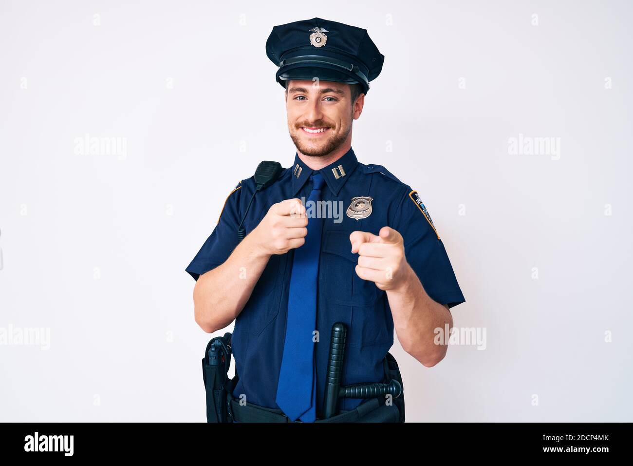 Young caucasian man wearing police uniform pointing fingers to camera ...