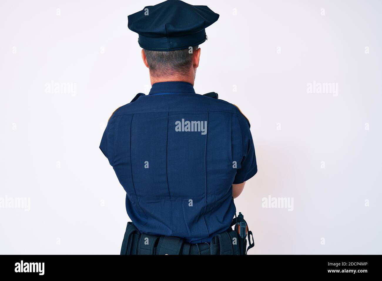 Young caucasian man wearing police uniform standing backwards looking ...