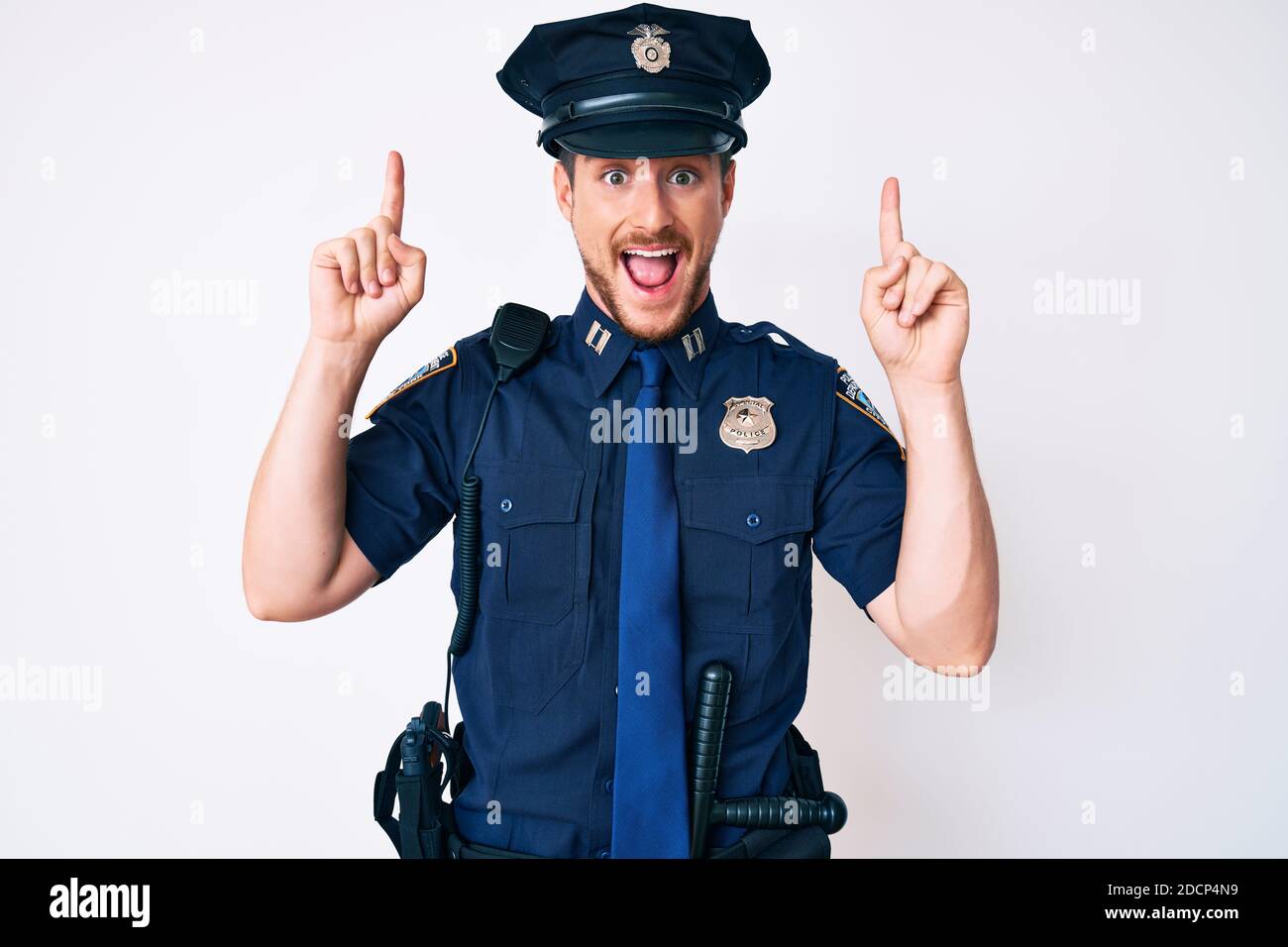Young caucasian man wearing police uniform smiling amazed and surprised ...