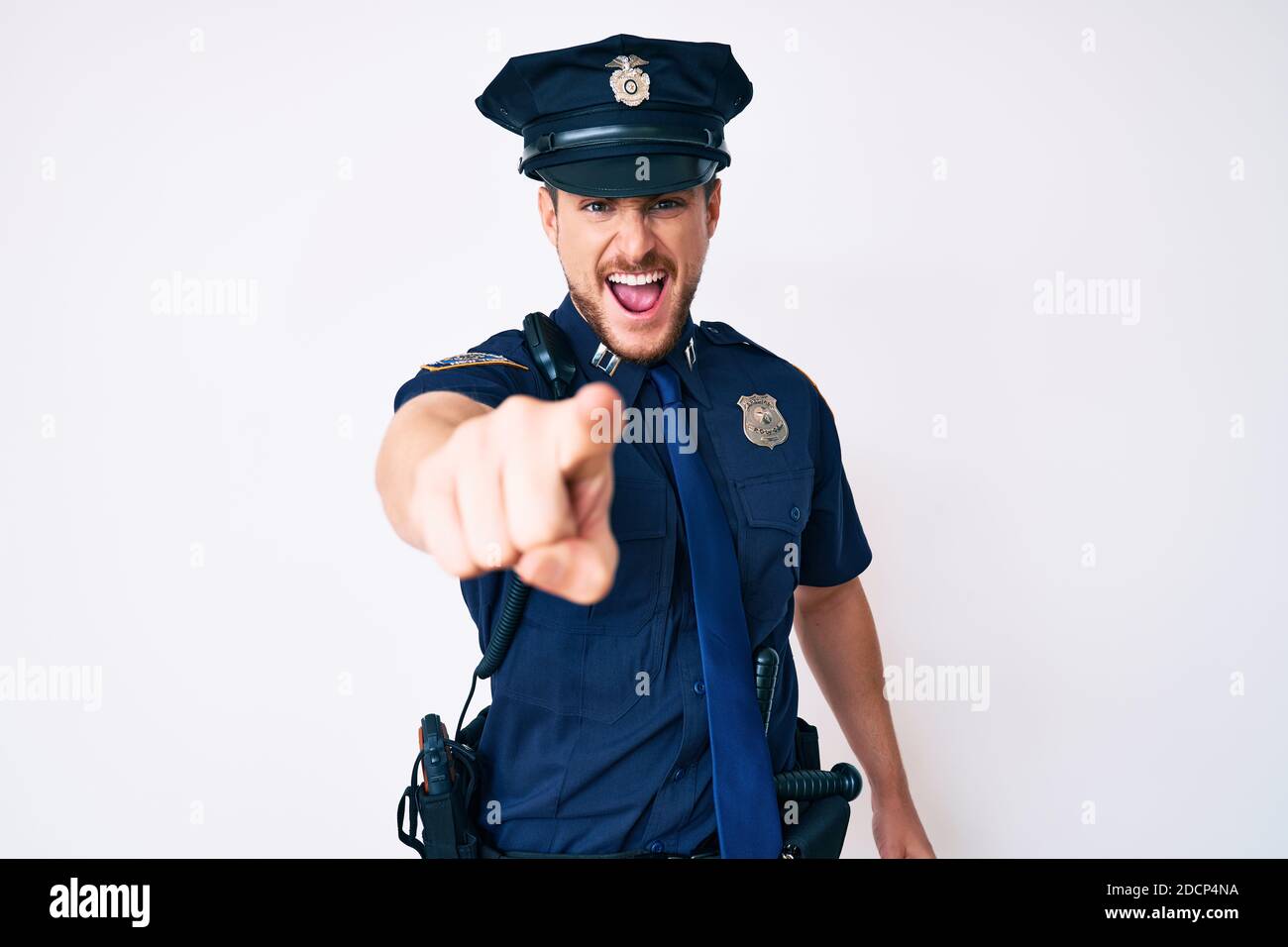 Young caucasian man wearing police uniform pointing displeased and ...