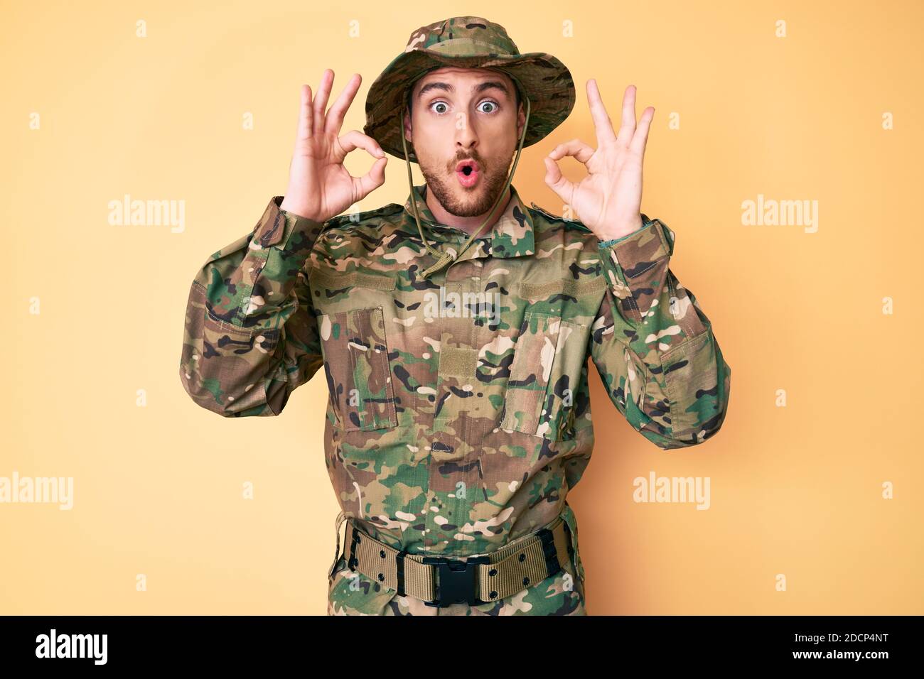 Young caucasian man wearing camouflage army uniform looking surprised ...
