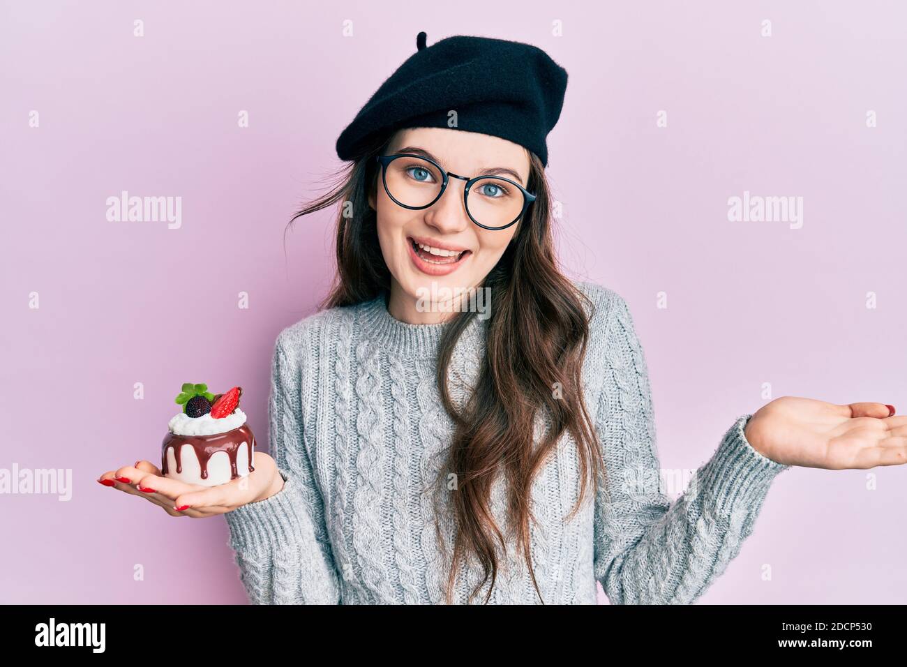Young beautiful caucasian girl wearing french beret holding cake ...