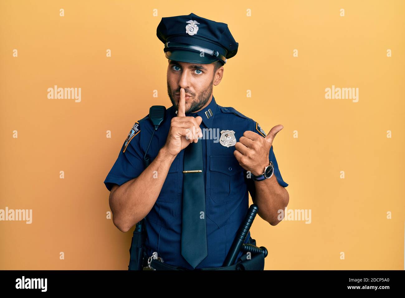 Handsome hispanic man wearing police uniform asking to be quiet with ...