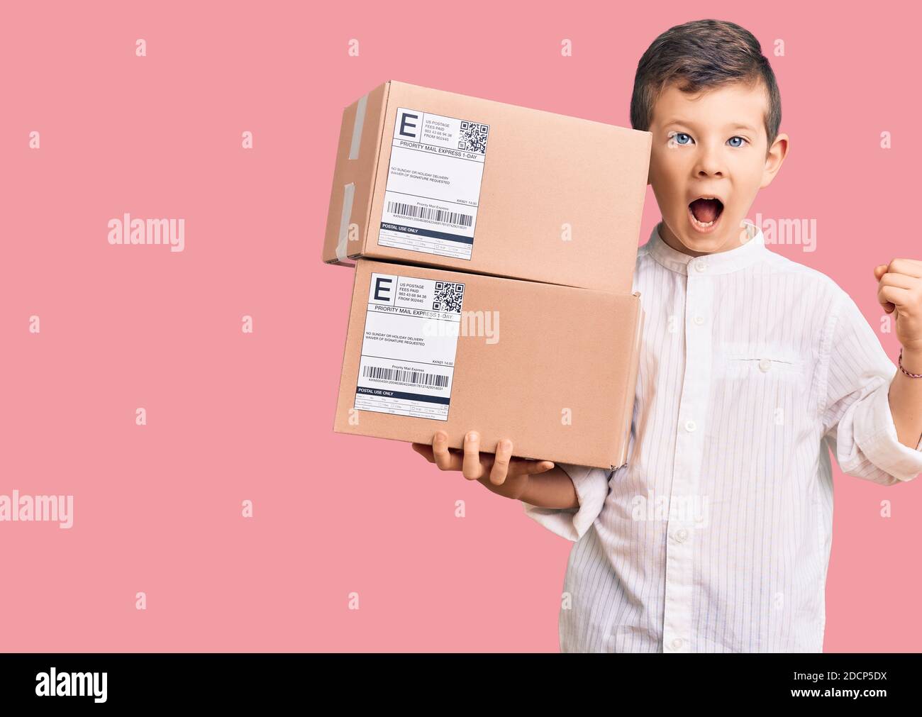Cute blond kid holding delivery package screaming proud, celebrating ...
