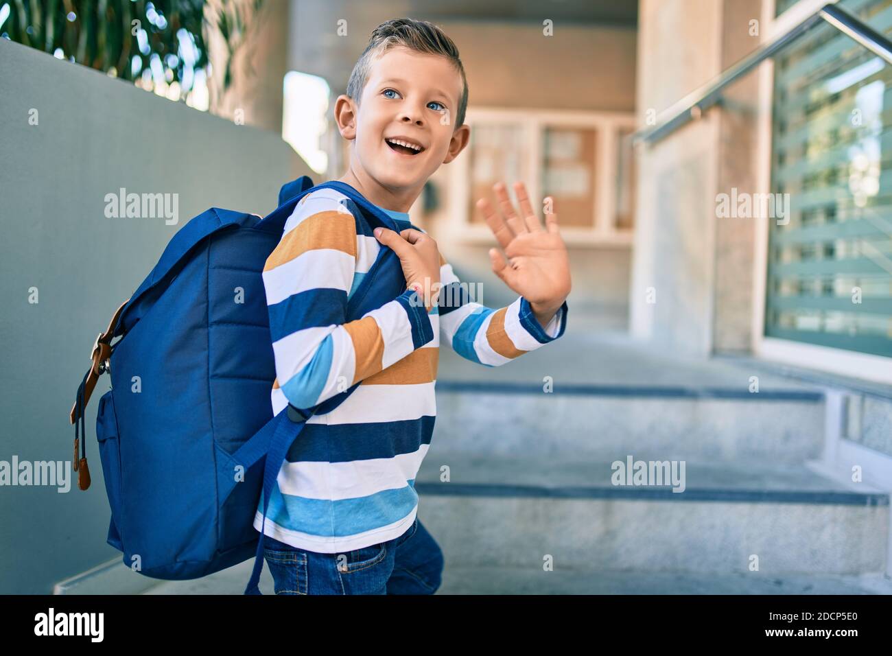 Adorable caucasian student boy smiling happy saying goodbye at the ...