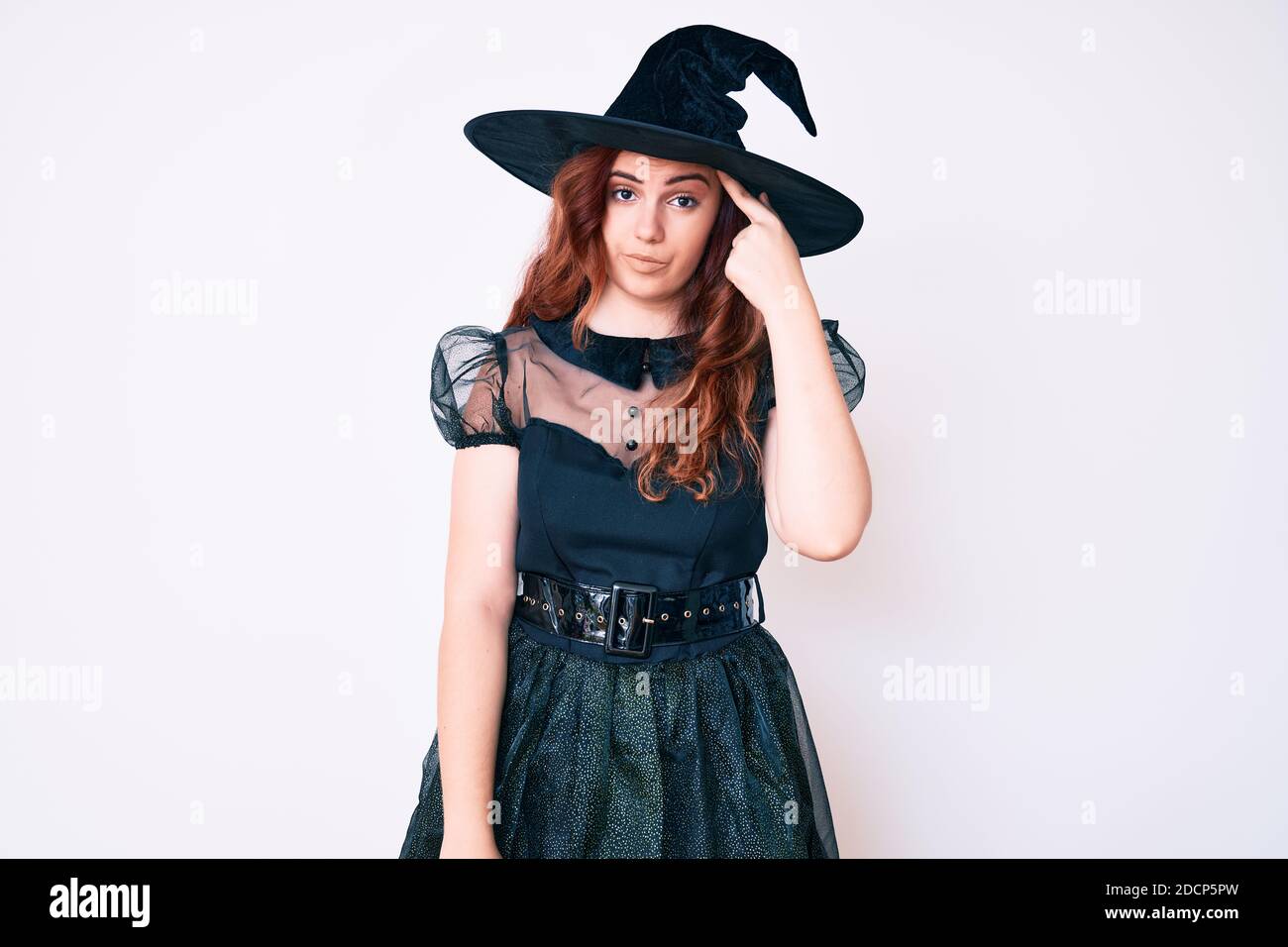 Young beautiful woman wearing witch halloween costume pointing unhappy ...