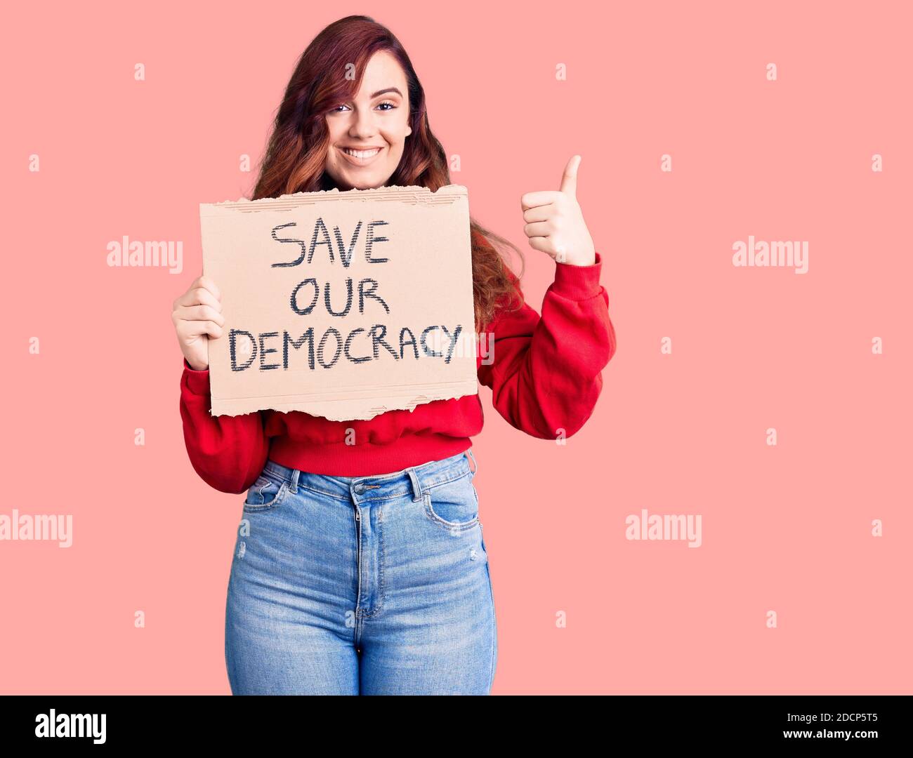 Young beautiful woman holding save our democracy protest banner smiling ...