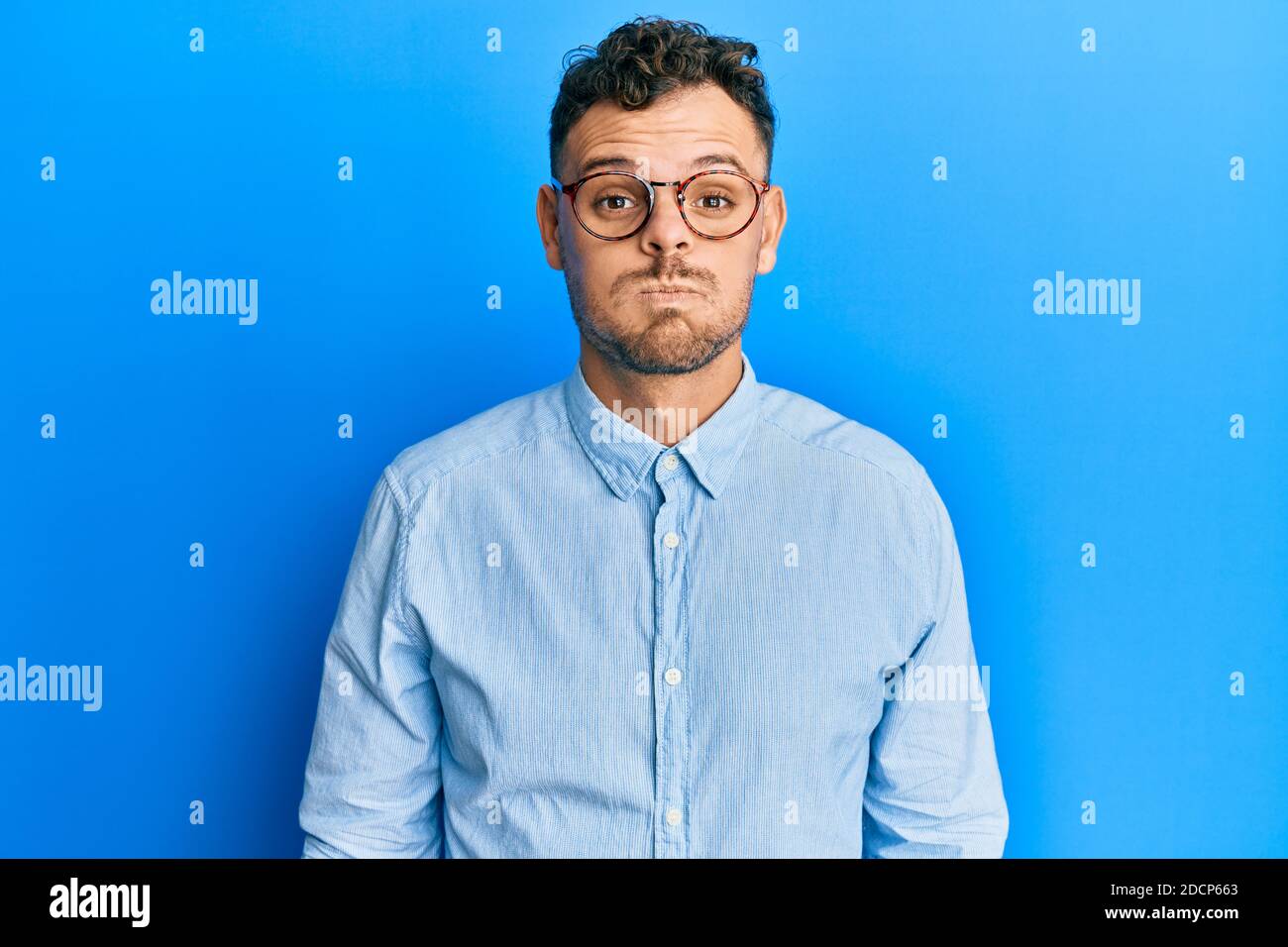 Handsome man with beard wearing casual clothes and glasses showing and ...