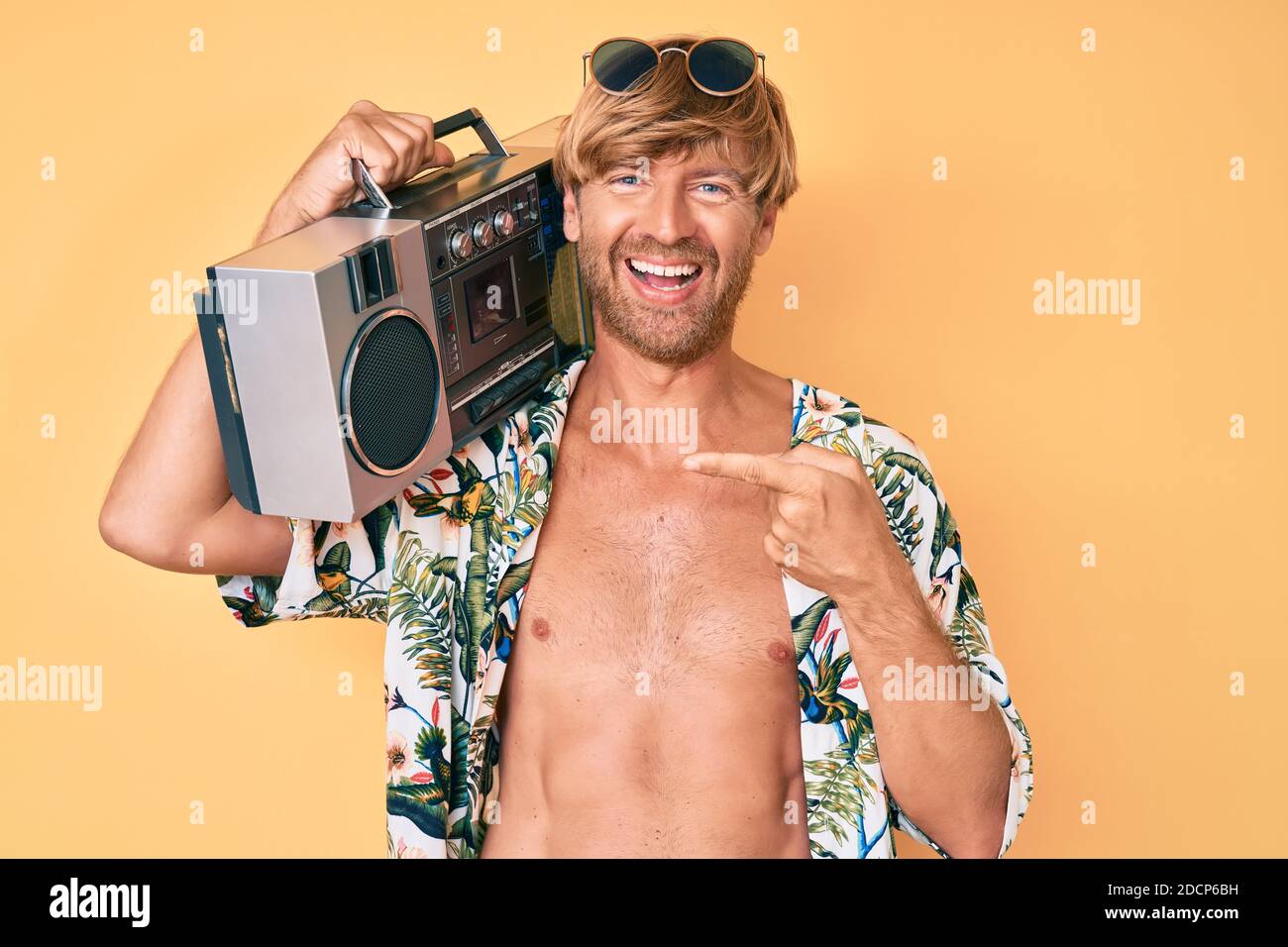 Young blond man wearing summer style holding boom box celebrating crazy ...