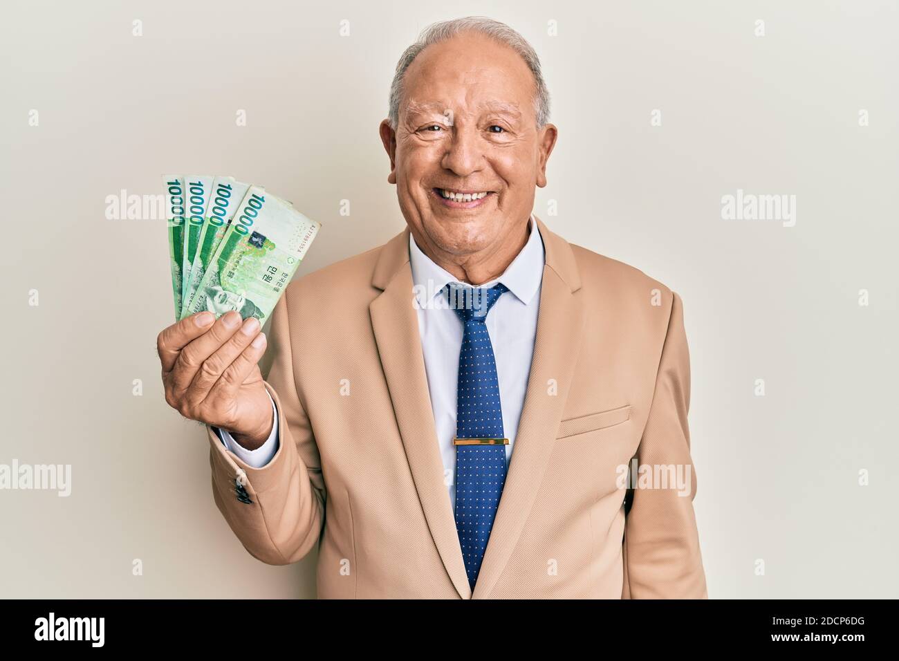 Senior caucasian man holding 10000 south korean won banknotes looking ...