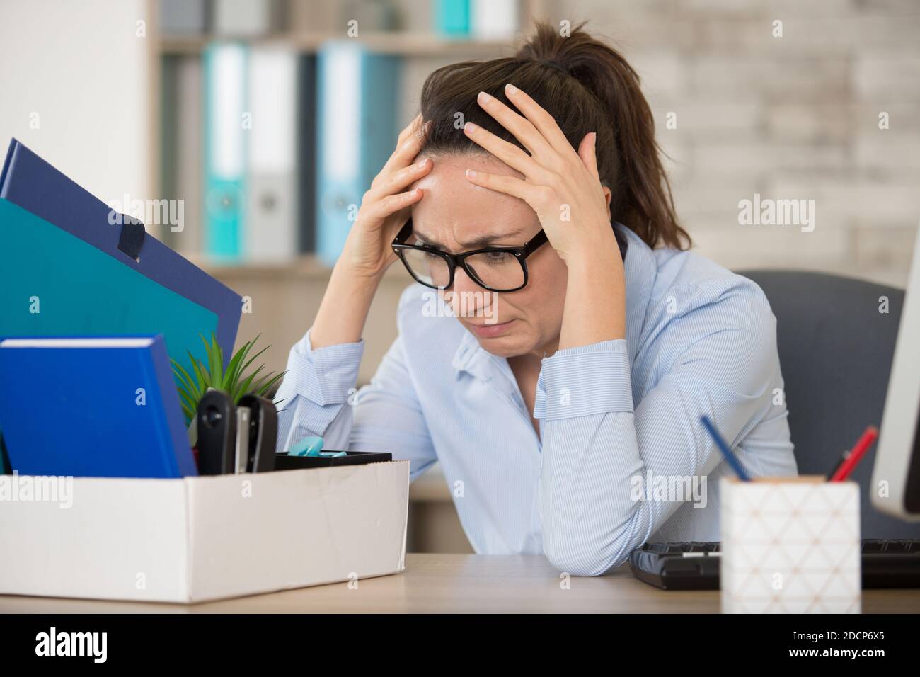 sad female office worker with box of her personal stuff Stock Photo - Alamy