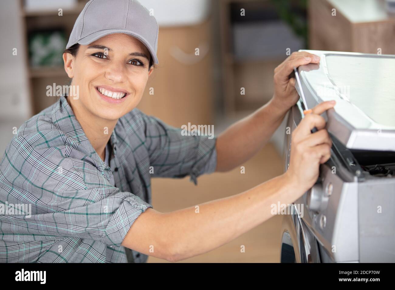 female technician repairing a washing machine Stock Photo - Alamy