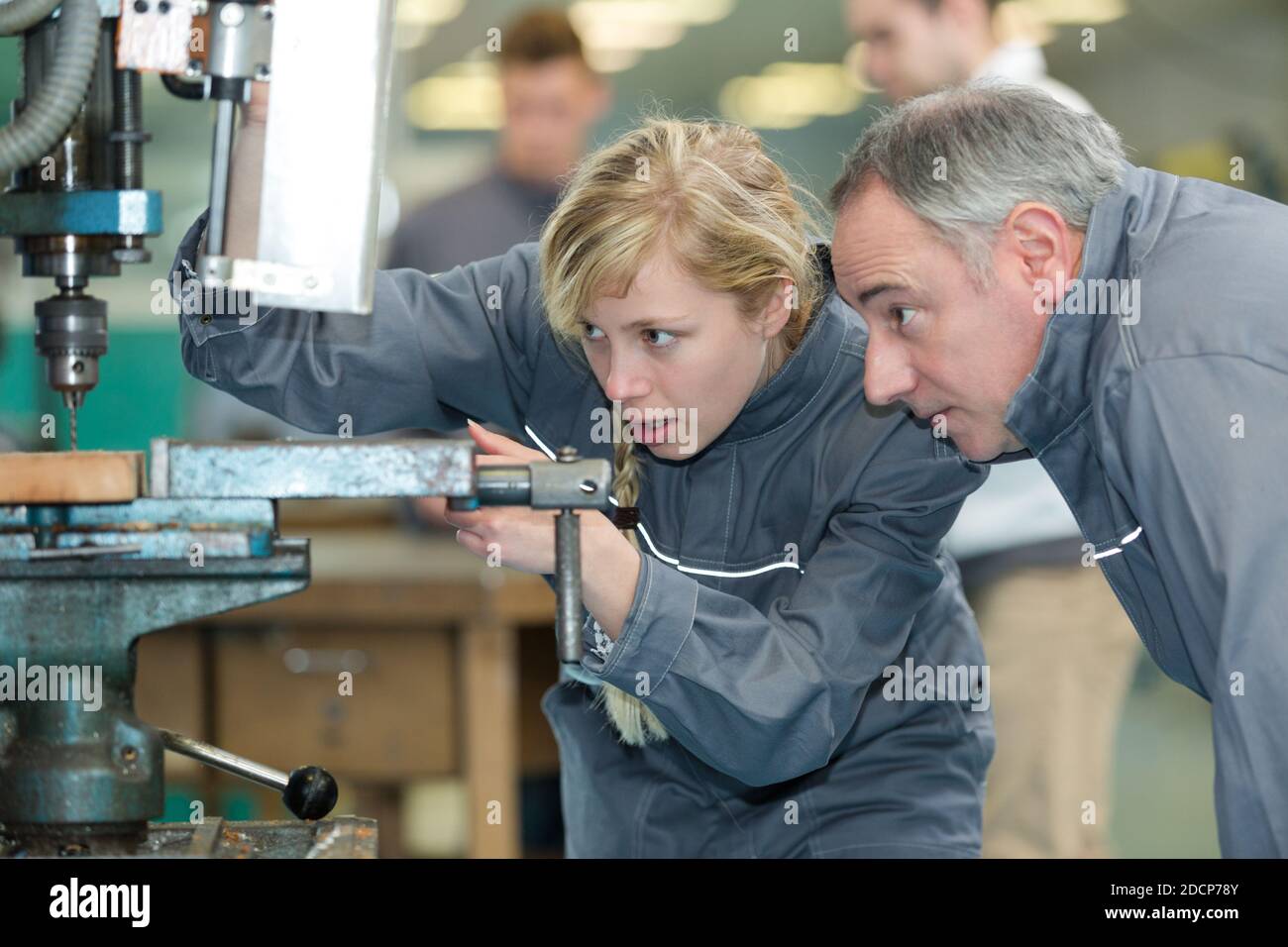 engineer training female apprentice on milling machine Stock Photo - Alamy