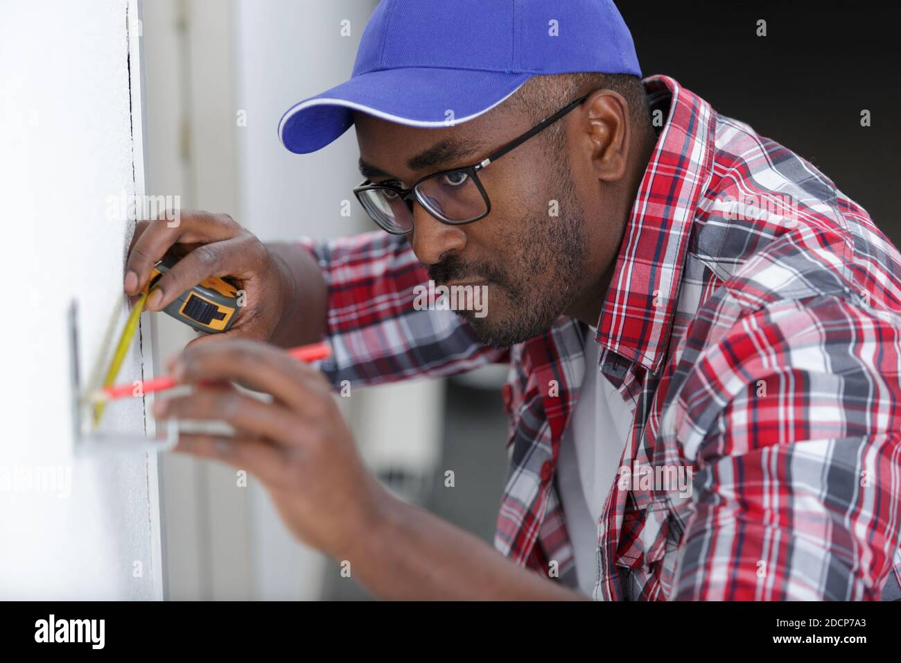 handyman measuring wall at construction site Stock Photo - Alamy