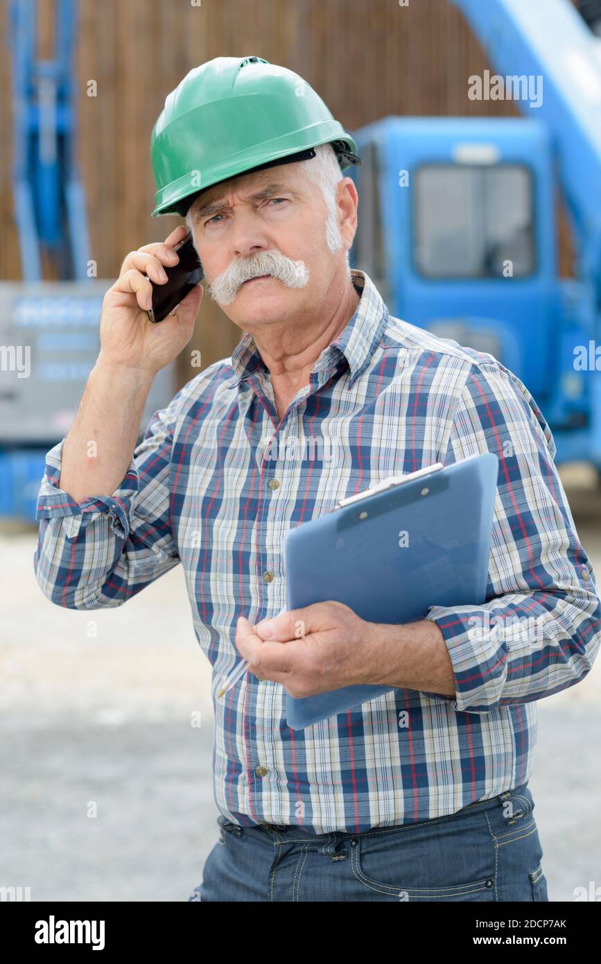 mature engineer wearing hardhat on the phone Stock Photo - Alamy