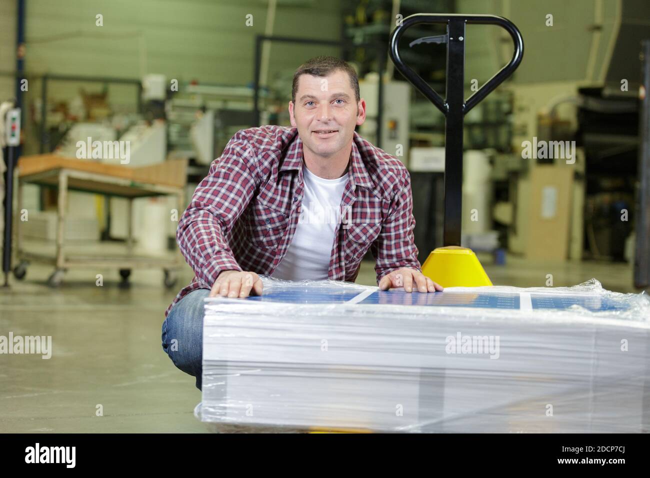 worker moving boards with pallet truck on a factory Stock Photo - Alamy