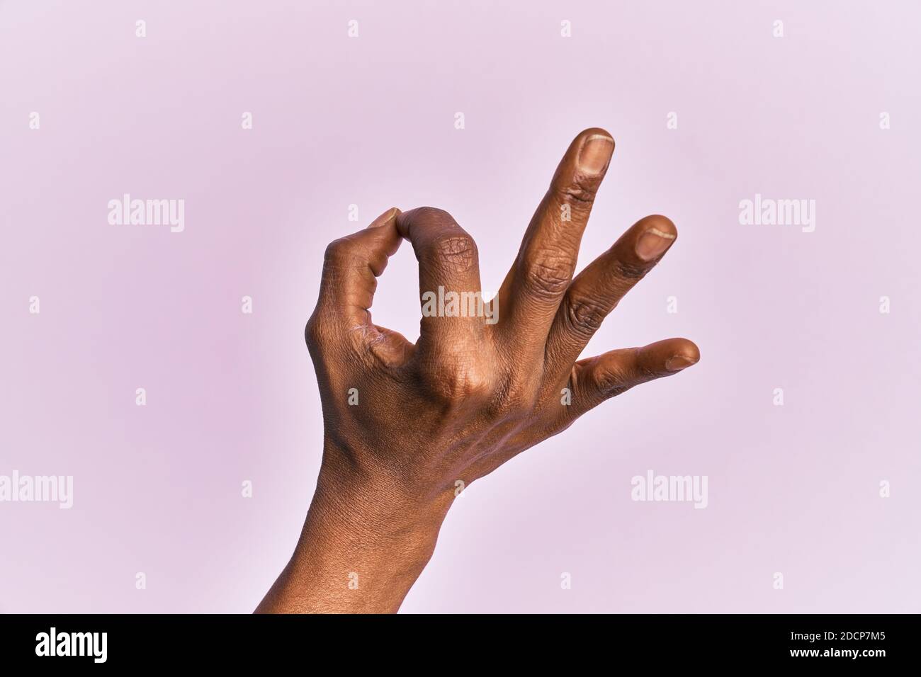 Arm and hand of black middle age woman over pink isolated background ...
