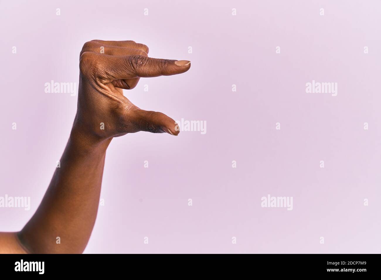 Arm and hand of black middle age woman over pink isolated background ...