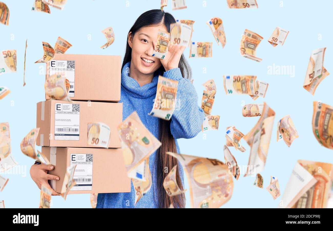 Young beautiful chinese woman holding delivery cardboard boxes smiling ...