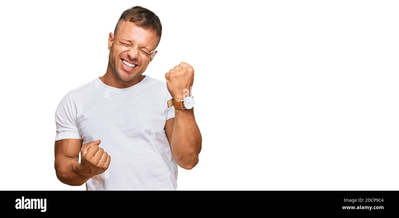 Handsome muscle man wearing casual white tshirt celebrating surprised ...