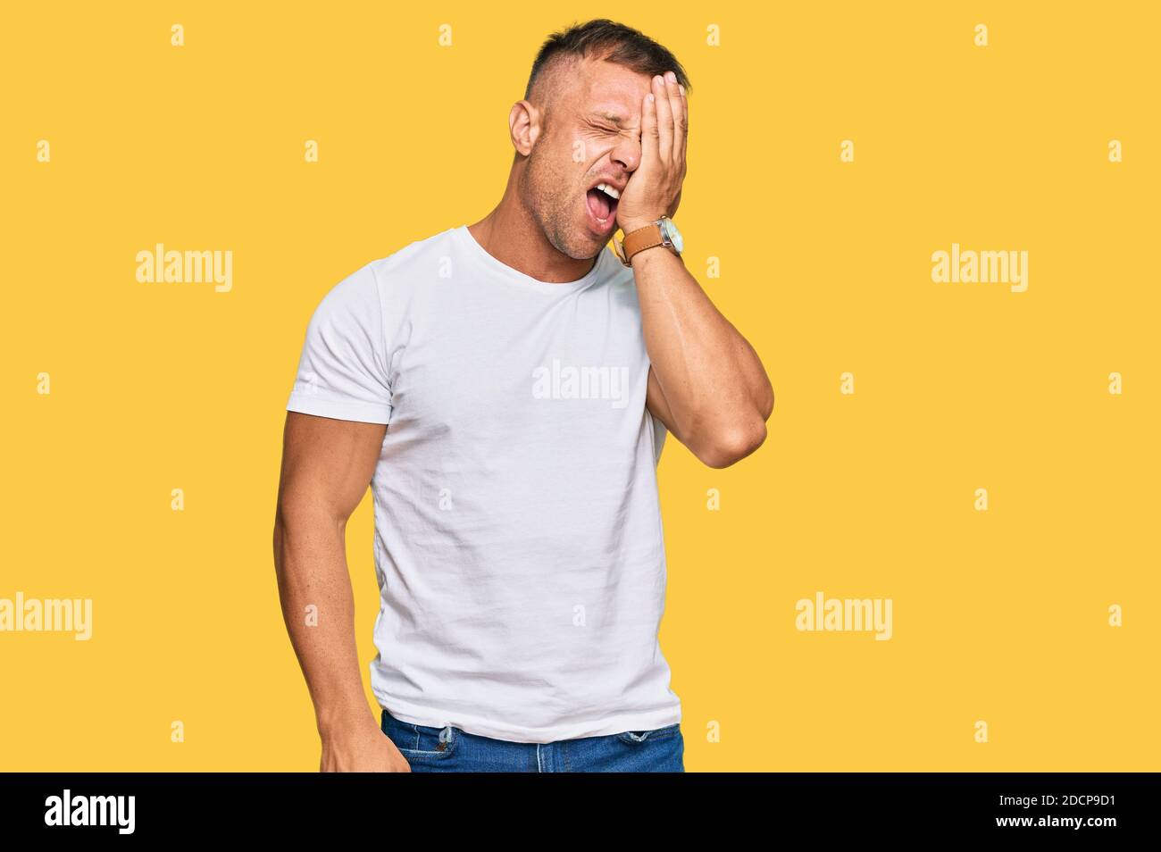 Handsome muscle man wearing casual white tshirt yawning tired covering ...