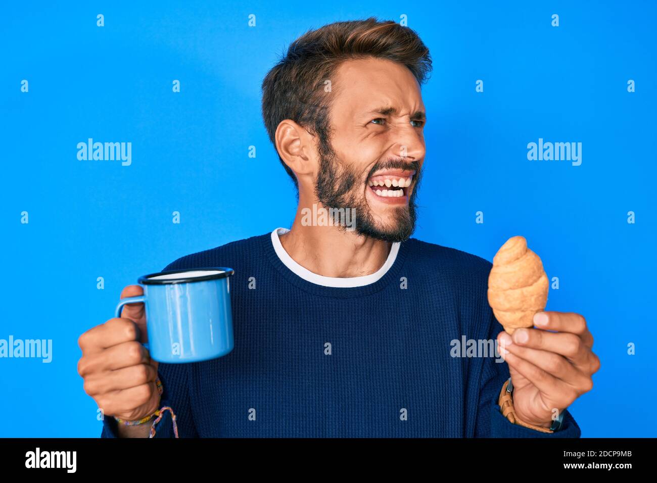 Handsome caucasian man with beard drinking a cup of coffee and ...