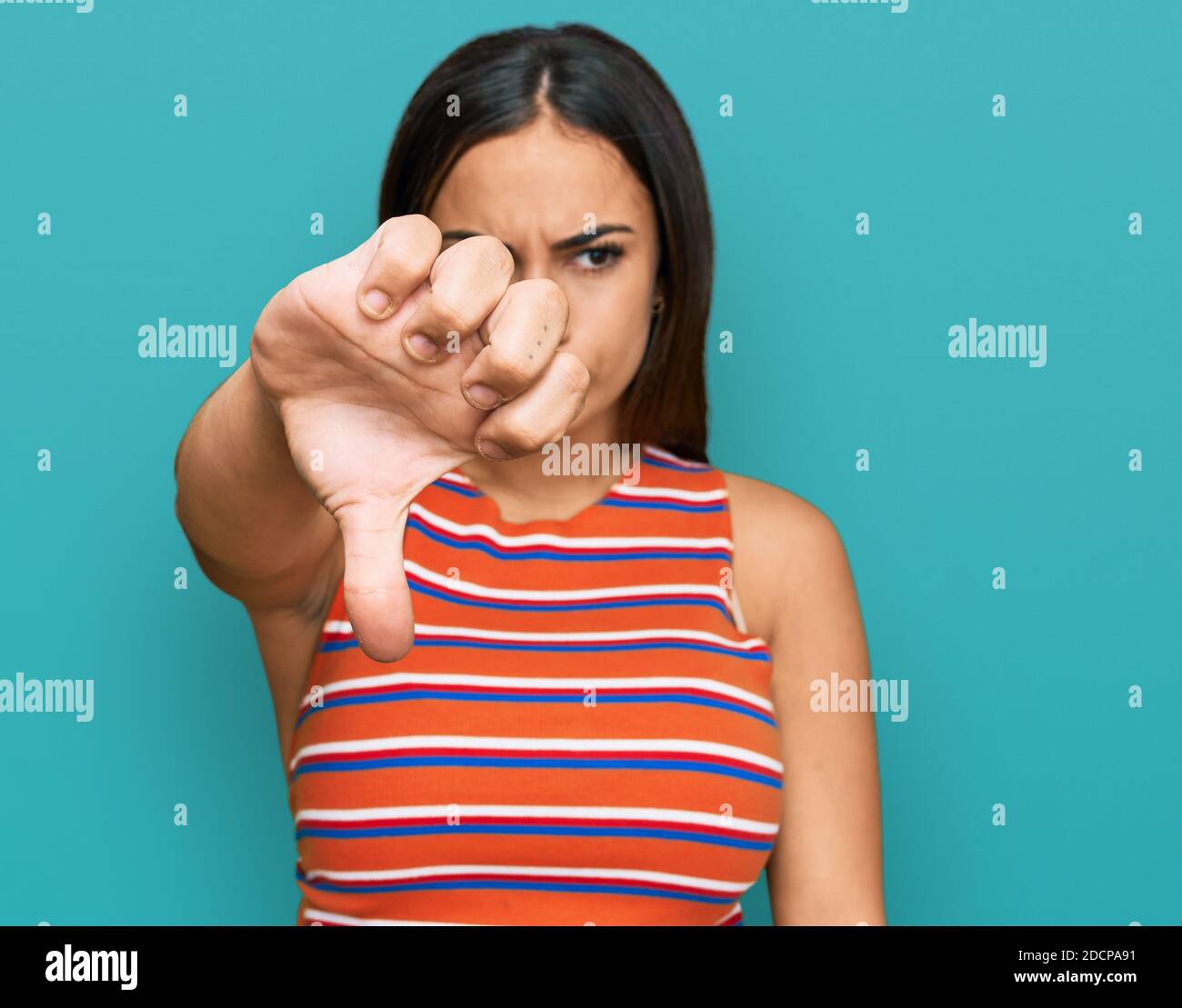 Young brunette woman wearing casual clothes looking unhappy and angry ...