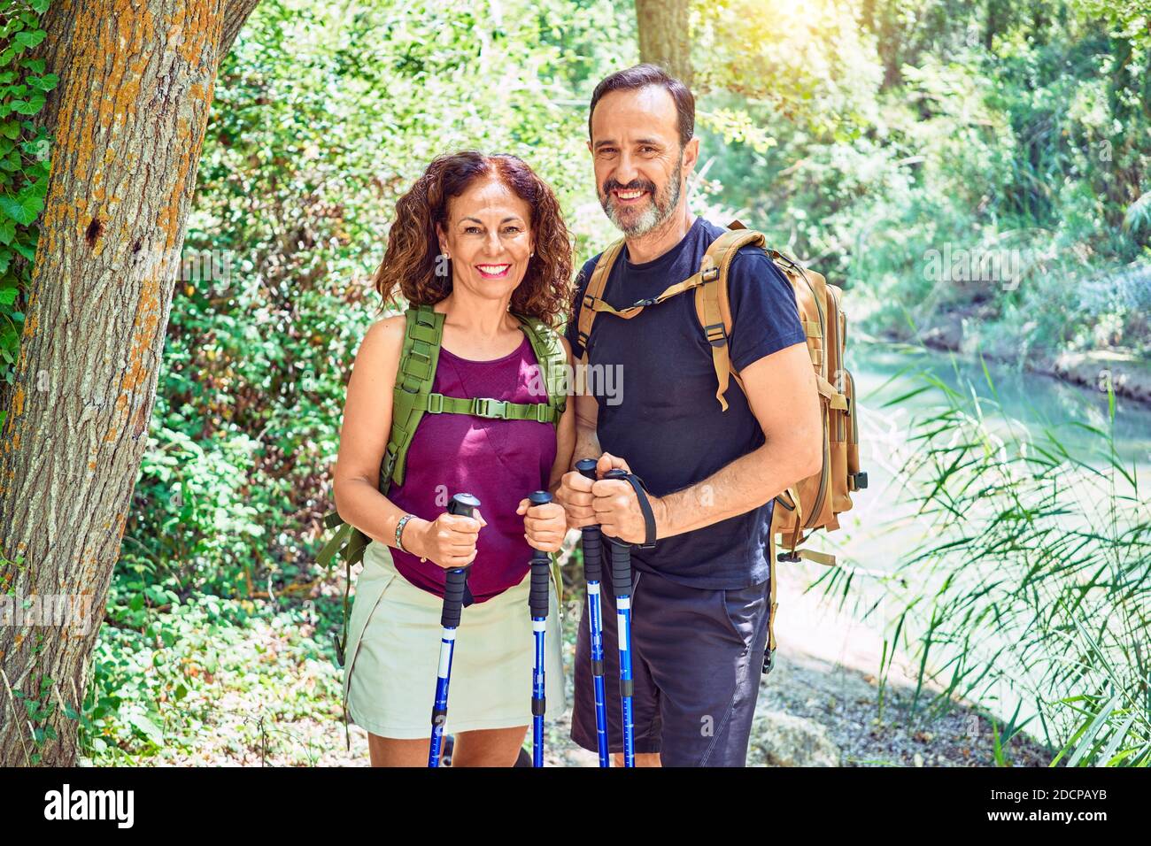 Beautiful couple of hiker wearing backpack smiling happy. Standing with ...
