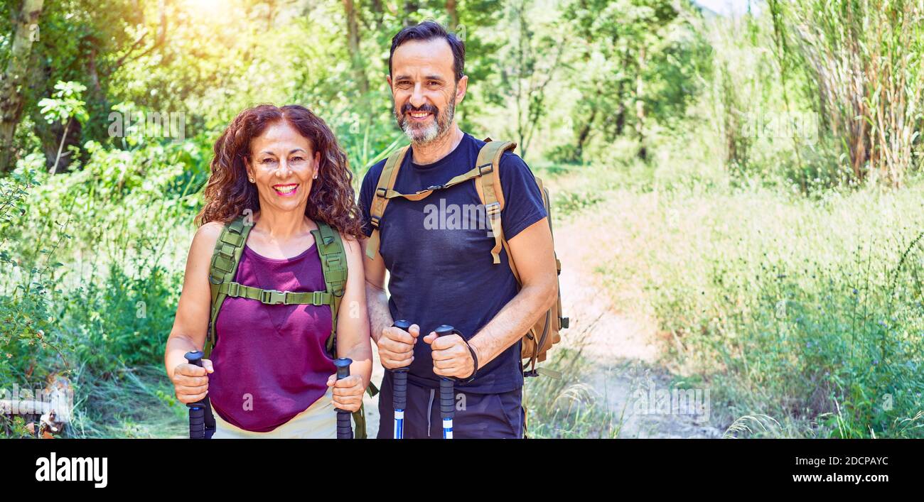 Beautiful couple of hiker wearing backpack smiling happy. Standing with ...