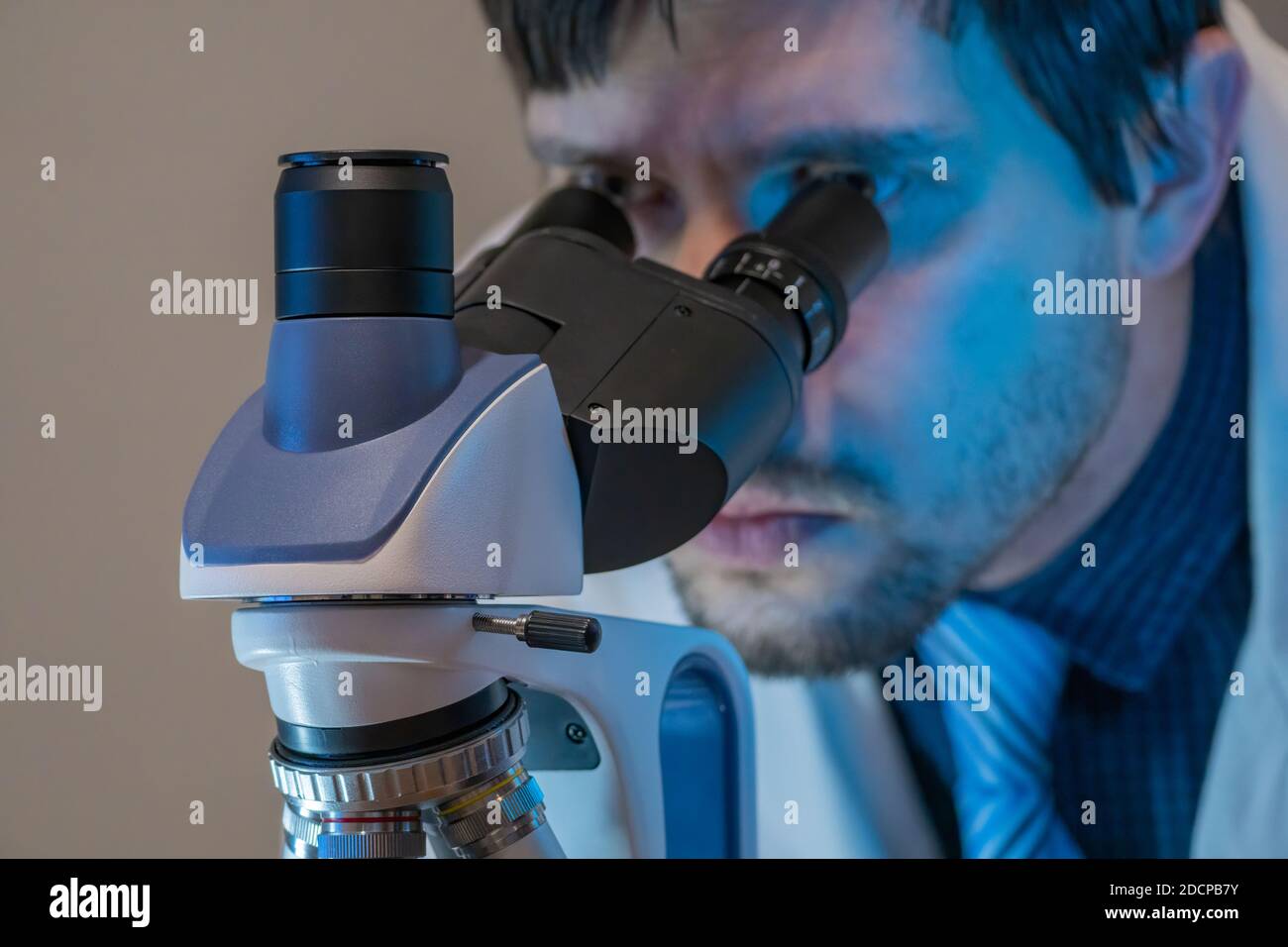 Young scientist is looking inside microscope in laboratory Stock Photo ...