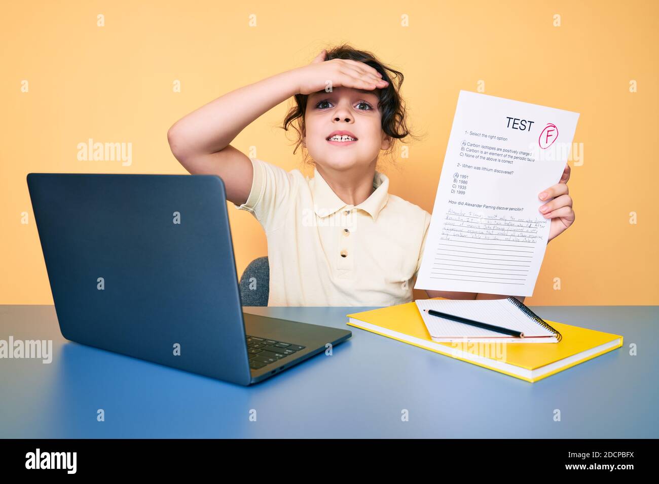 Cute hispanic child showing failed exam sitting on the desk stressed ...