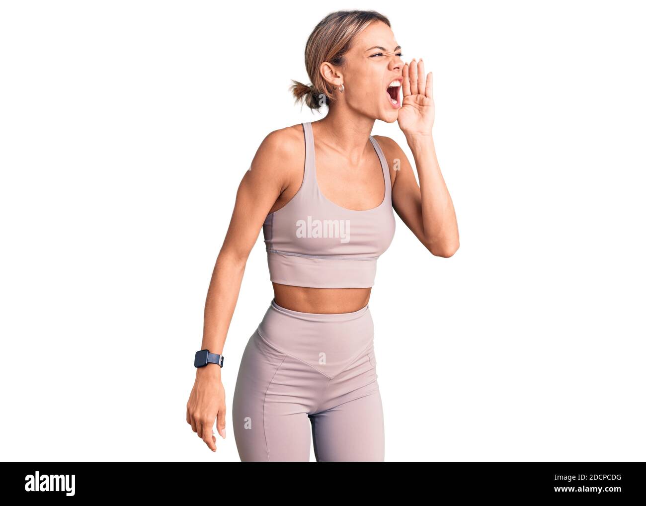 Beautiful caucasian woman wearing sportswear shouting and screaming ...