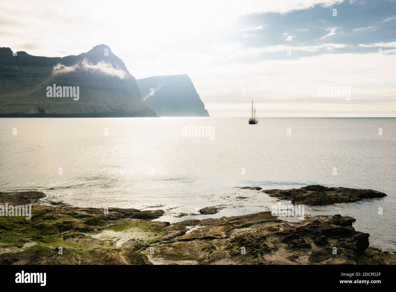 Amazing scenery of sailboat floating alone in calm sea under blue sky ...