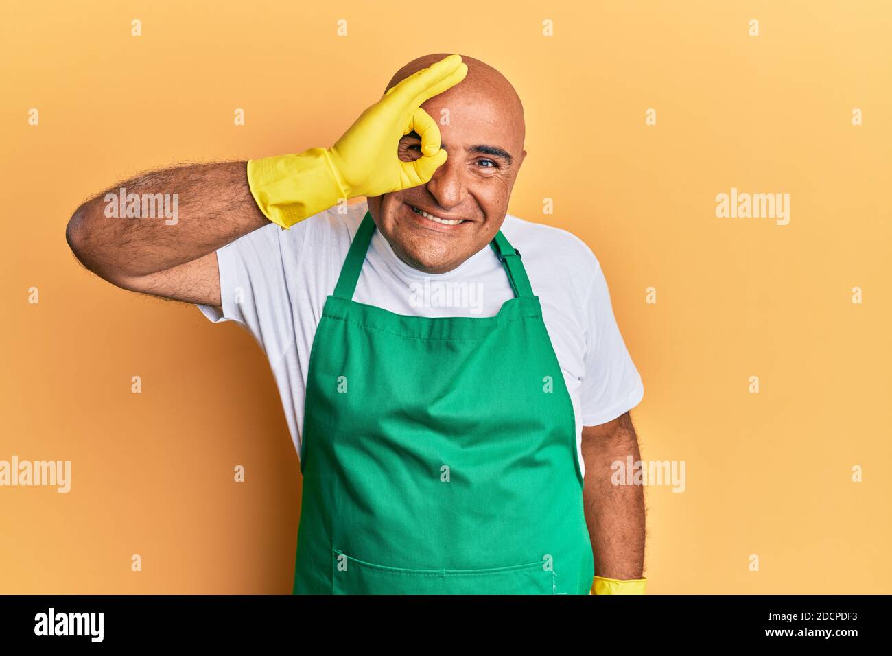 Mature middle east man wearing cleaner apron and gloves smiling happy ...
