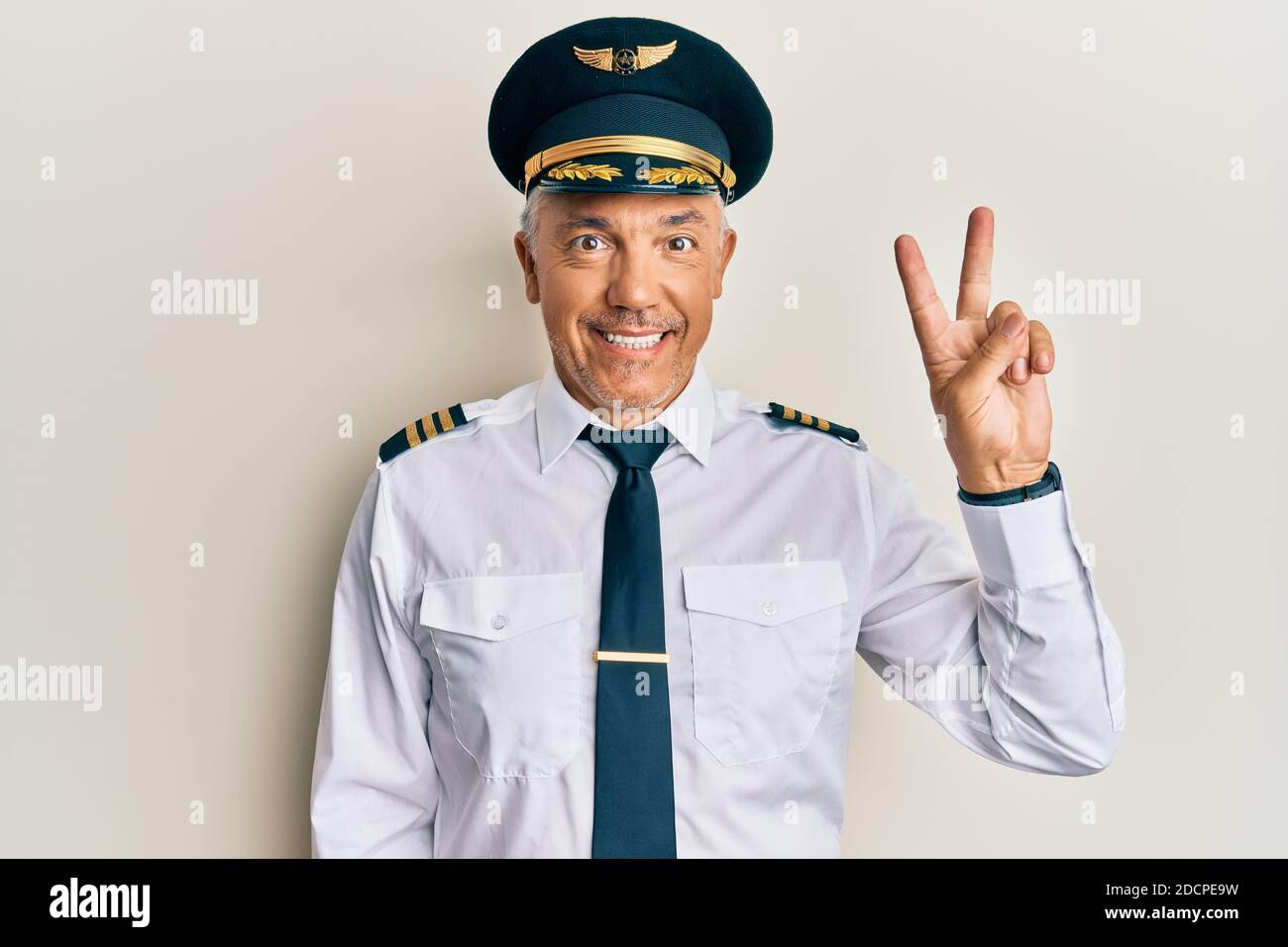 Handsome middle age mature man wearing airplane pilot uniform showing ...