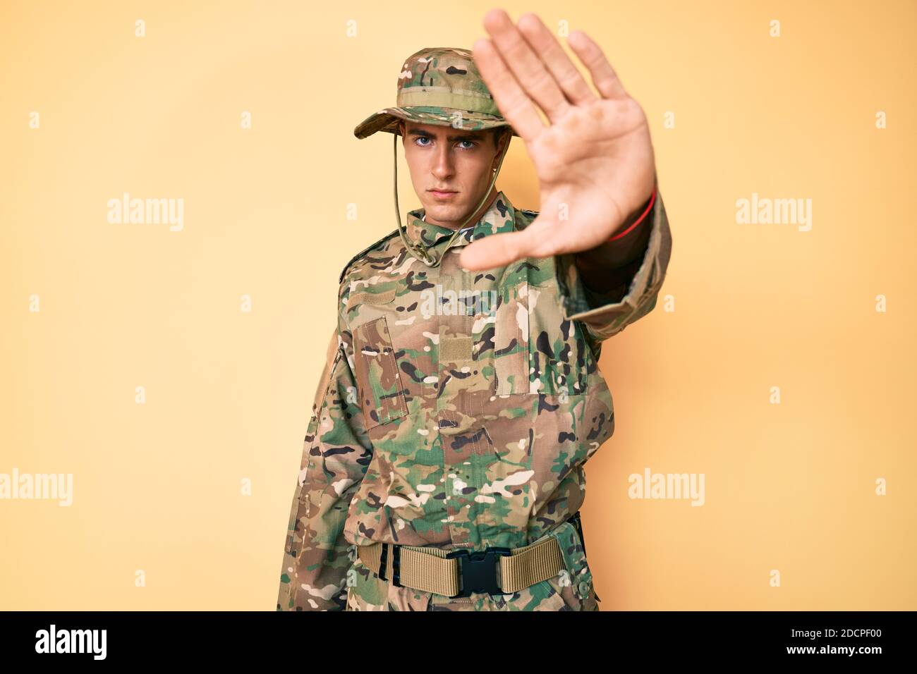Young handsome man wearing camouflage army uniform doing stop sing with ...