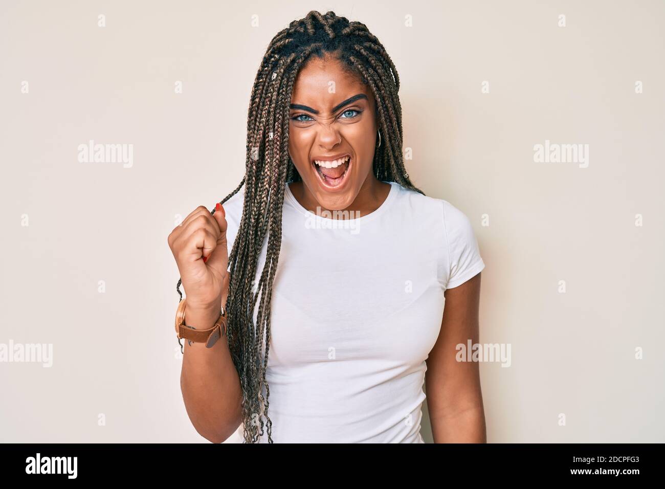 Young african american woman with braids wearing casual white tshirt ...