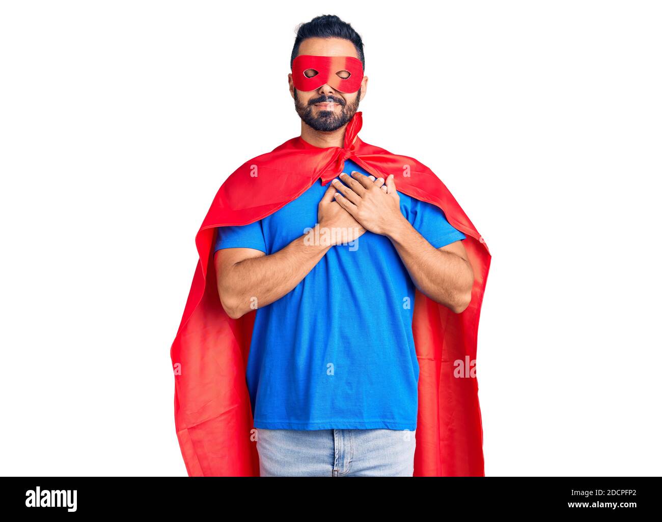 Young hispanic man wearing super hero costume smiling with hands on ...