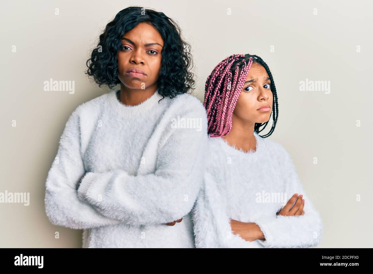 Beautiful african american mother and daughter with arms crossed ...